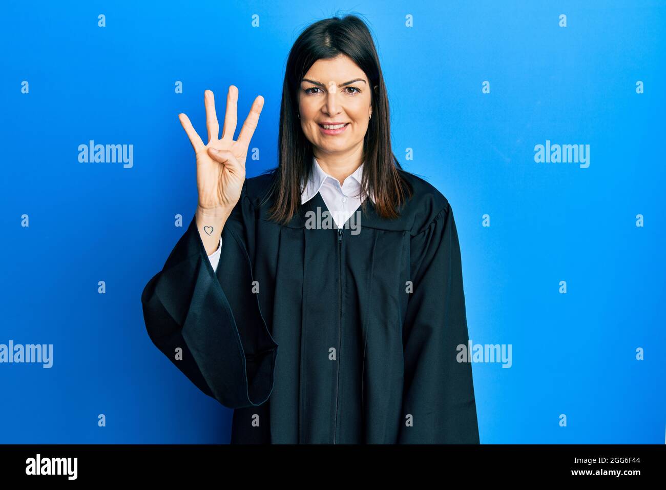 Young hispanic woman wearing judge uniform showing and pointing up with ...