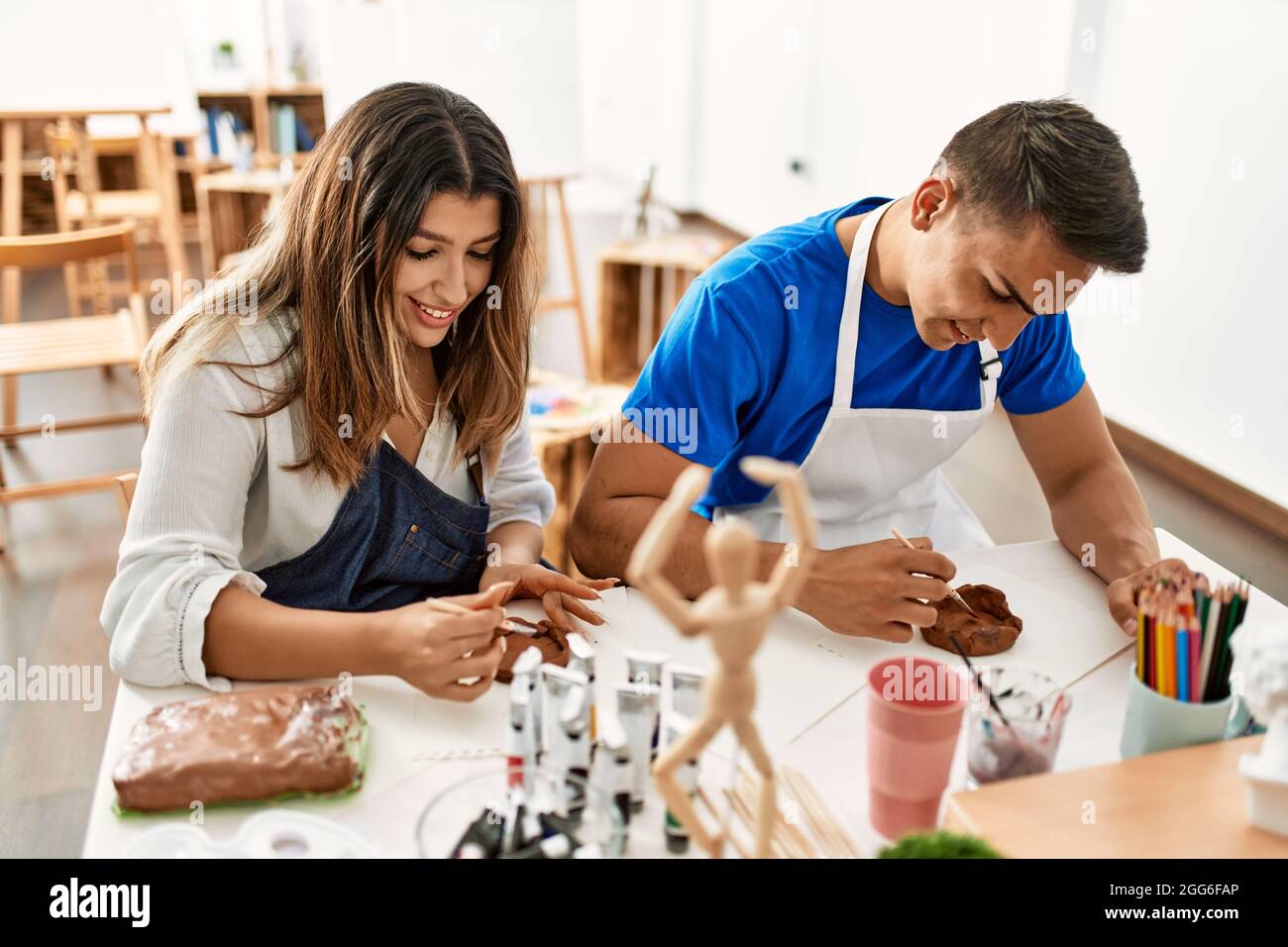 Two students smiling happy painting clay sculpture at art school Stock ...