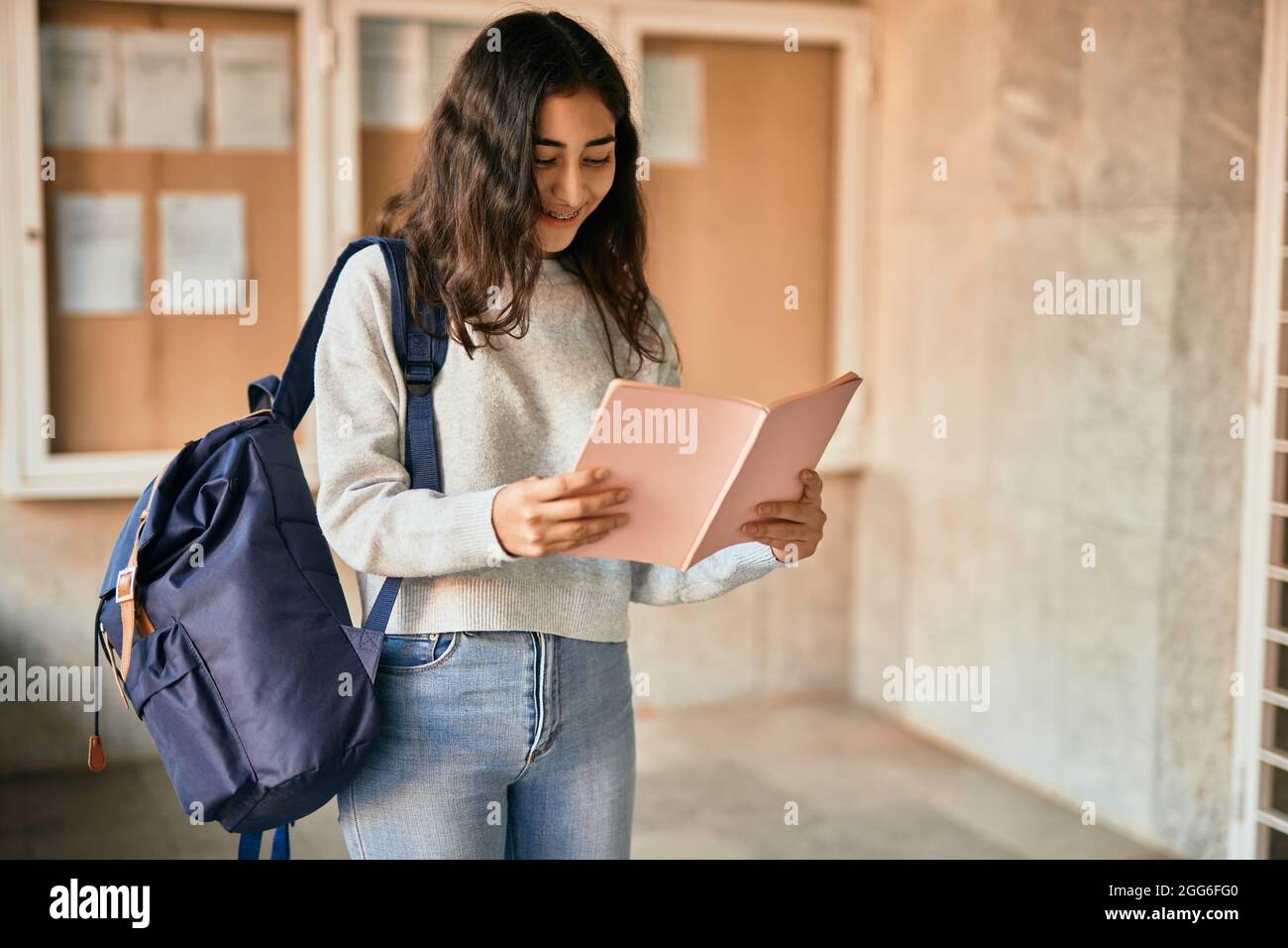 Young middle east student girl smiling happy reading book at the city ...