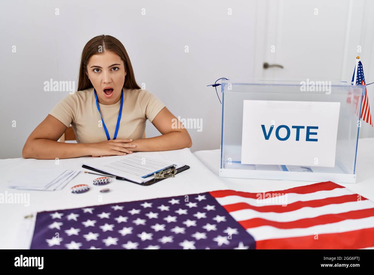 Young brunette woman at political election sitting by ballot scared and ...