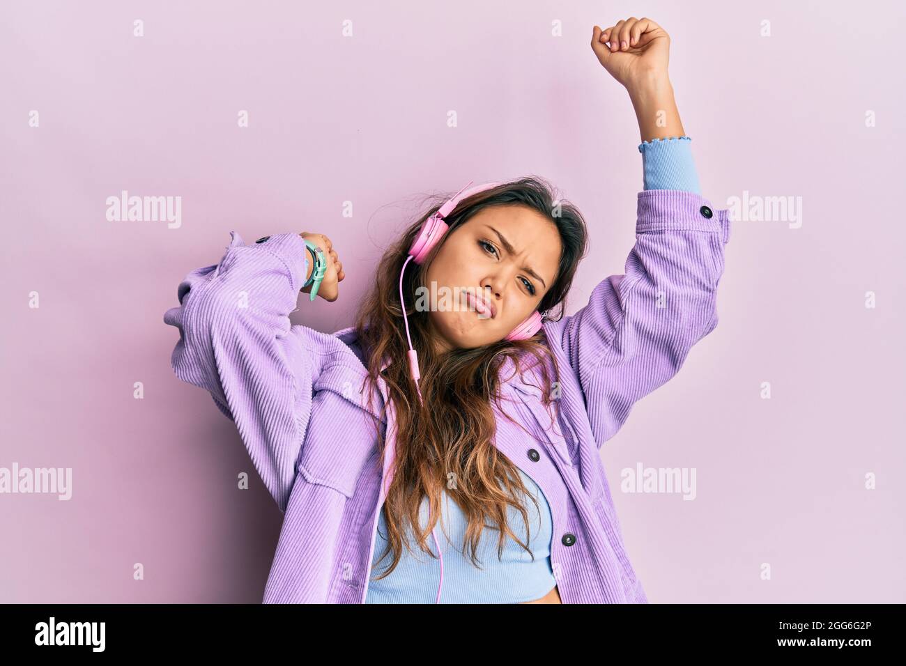 Young hispanic girl dancing and listening to music using headphones ...