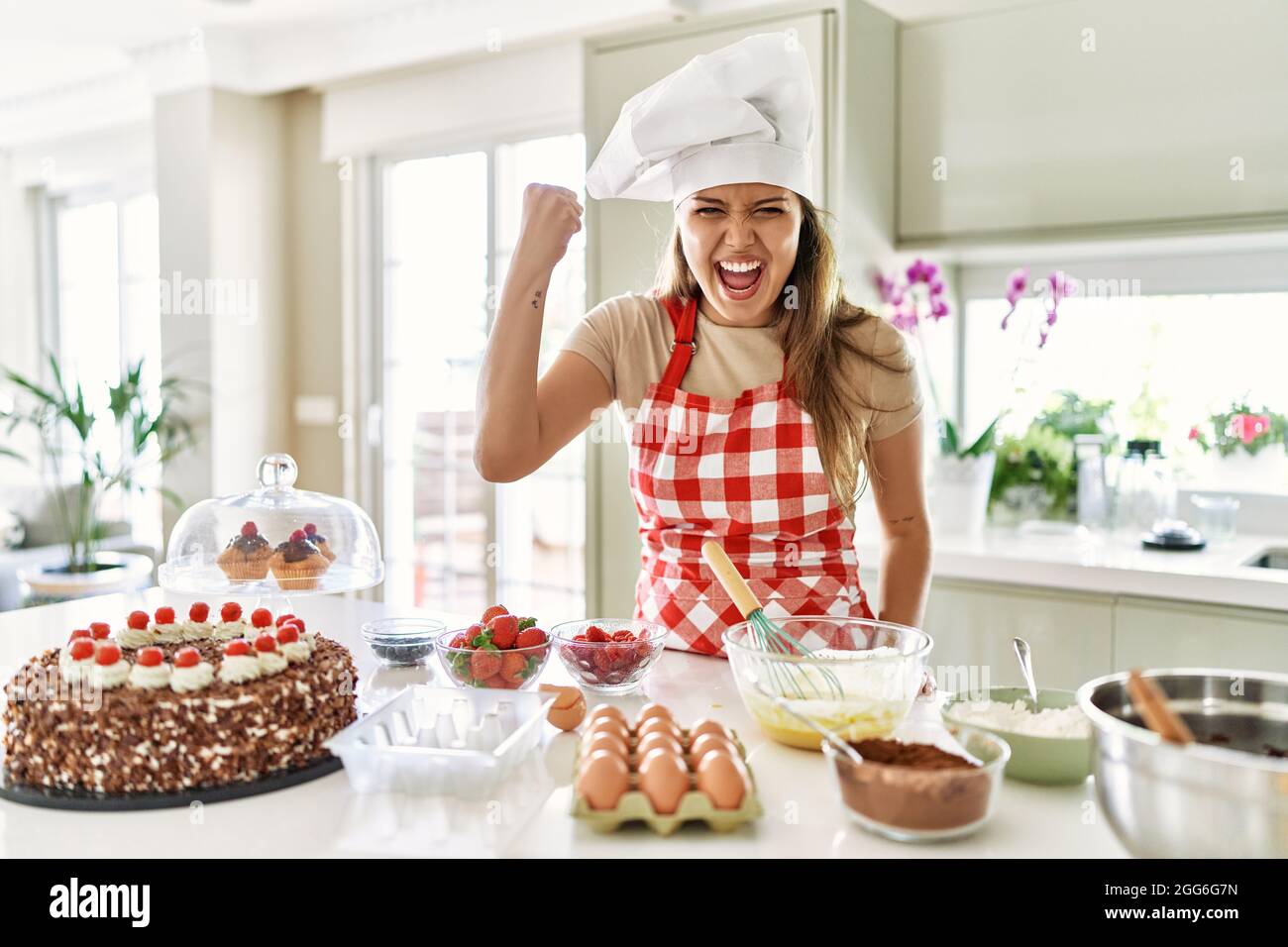 Beautiful young brunette pastry chef woman cooking pastries at the ...