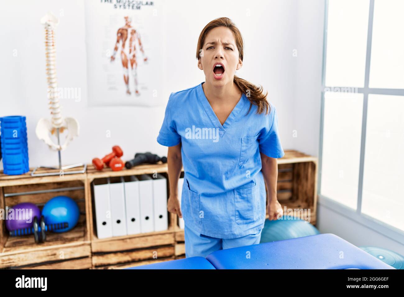 Middle age hispanic physiotherapist woman working at pain recovery ...