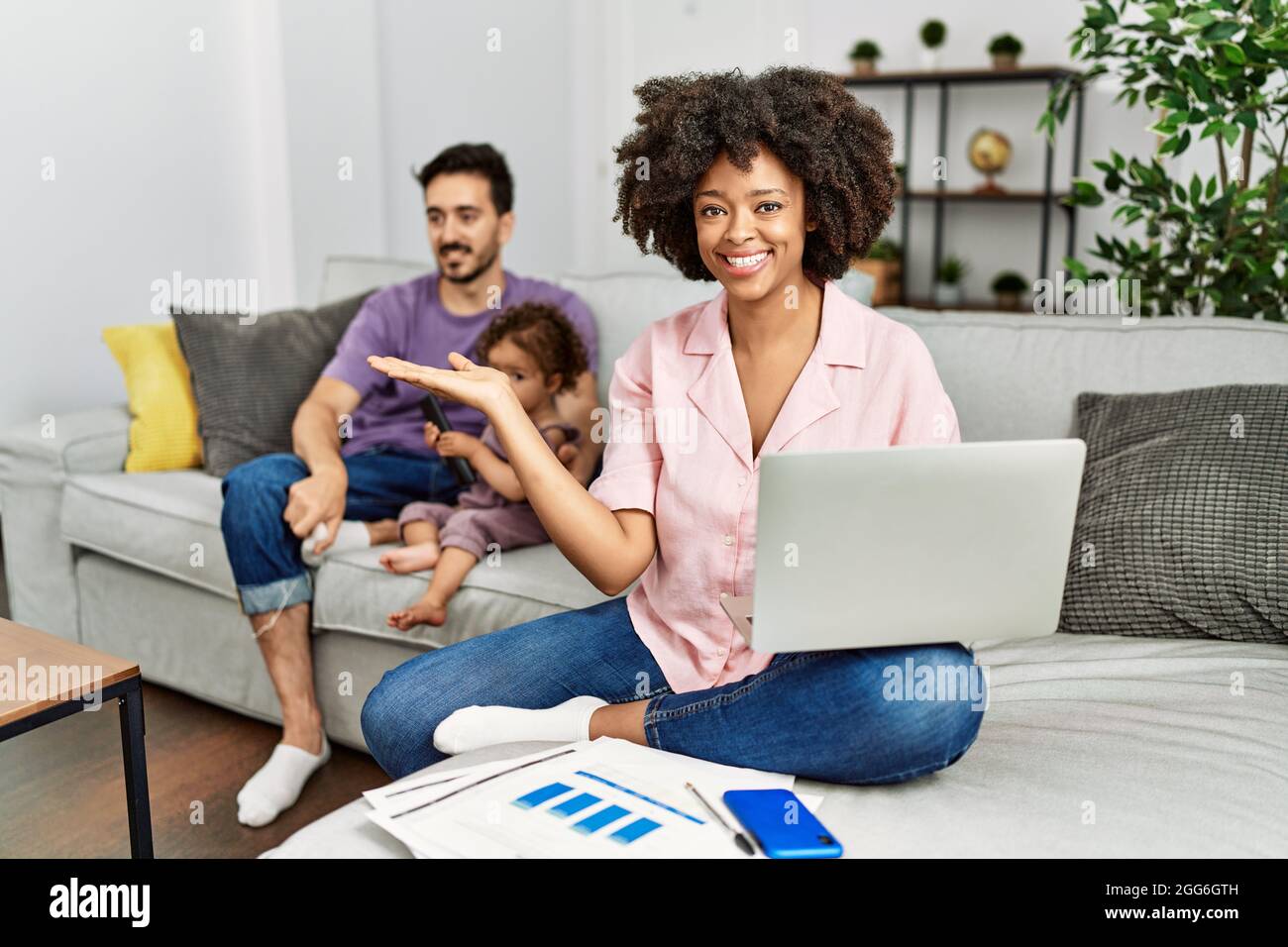 Mother of interracial family working using computer laptop at home ...