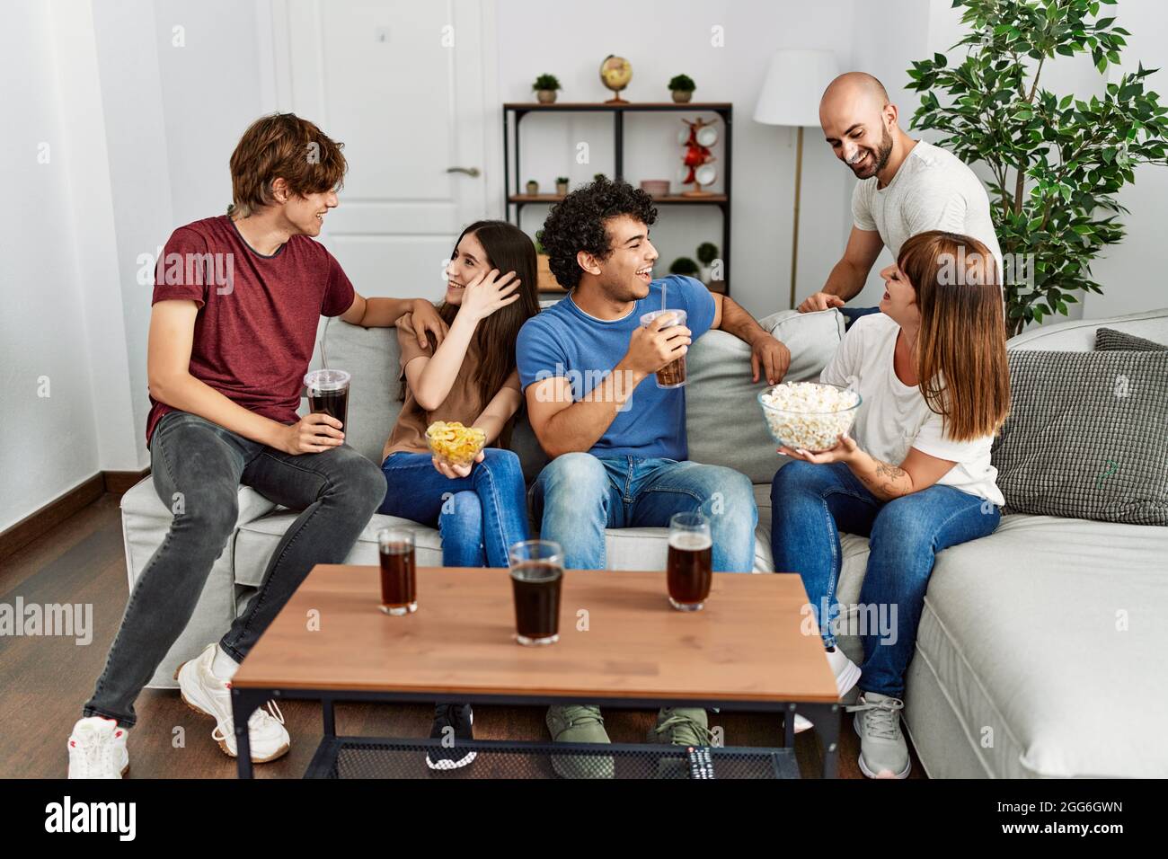 Group of young friends having party sitting on the sofa at home Stock ...