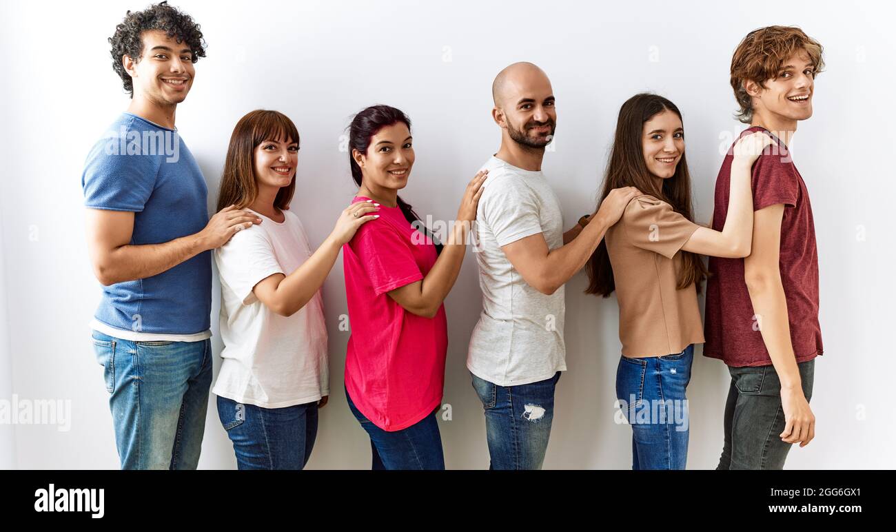 Group of young friends standing together over isolated background ...