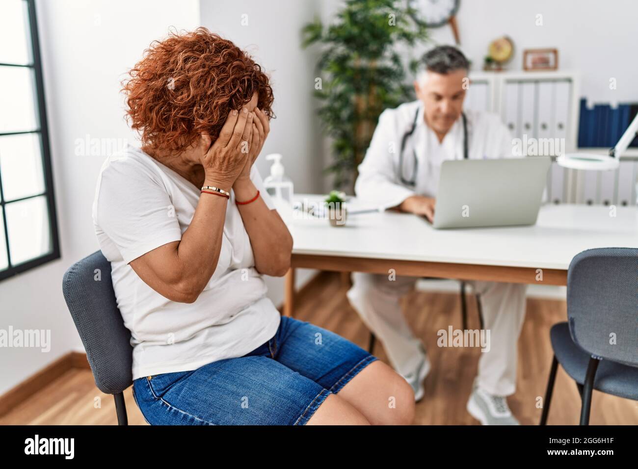 Senior woman sitting at doctor appointment with sad expression covering ...