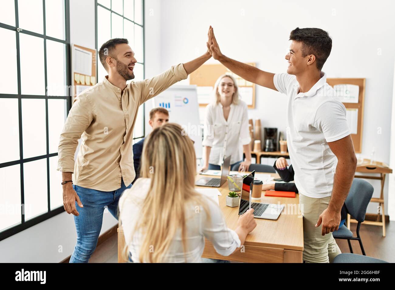 Two workers smiling happy high five during meeting at the office Stock ...