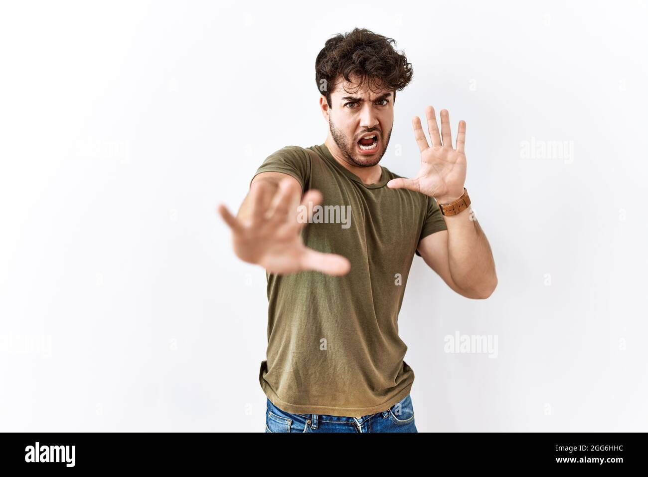 Hispanic man standing over isolated white background afraid and ...
