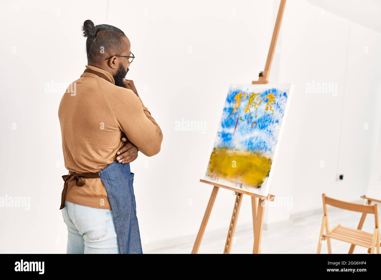 Young african american artist man on back view looking draw at art ...