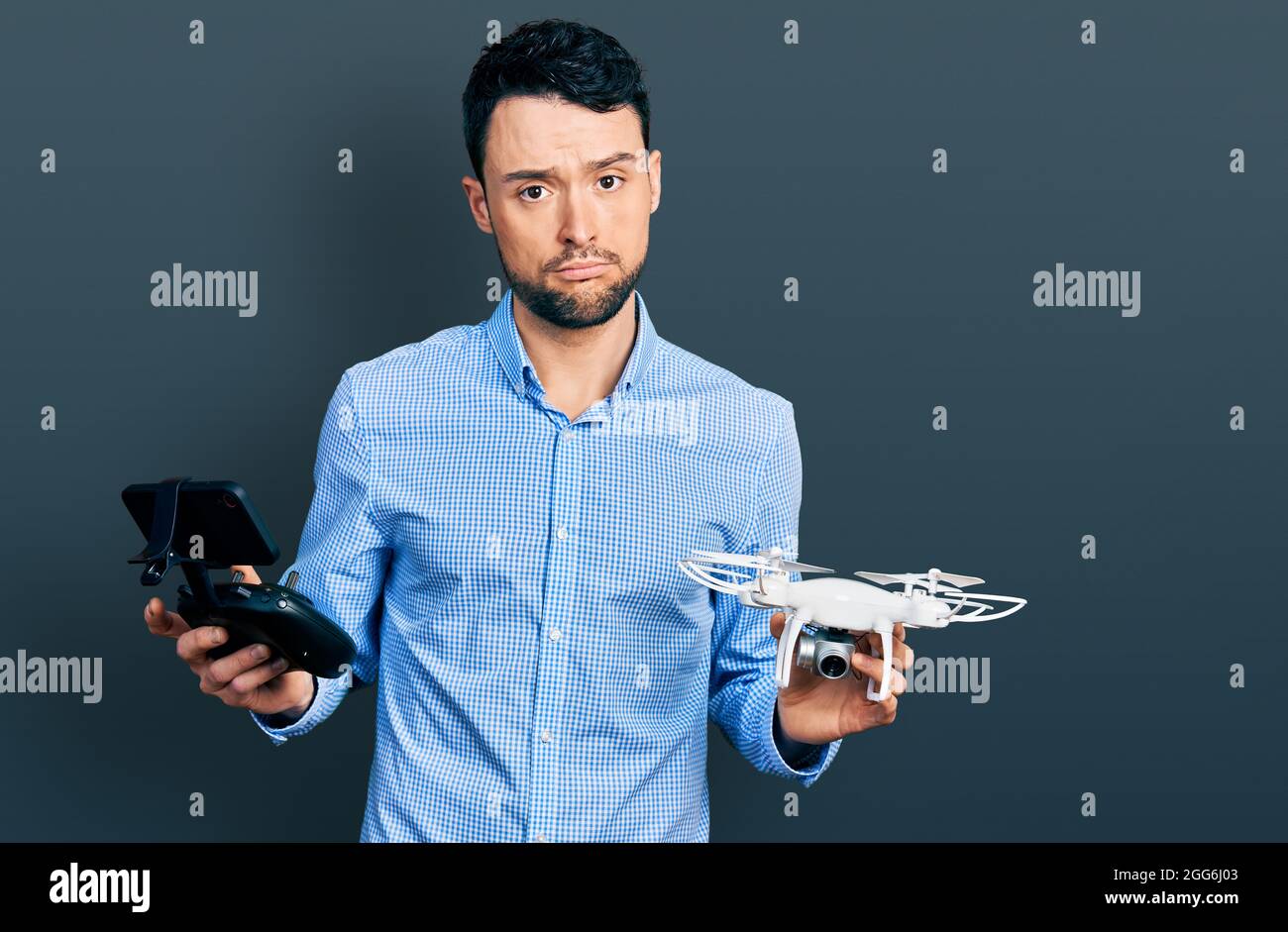 Hispanic man with beard using drone with remote control depressed and ...