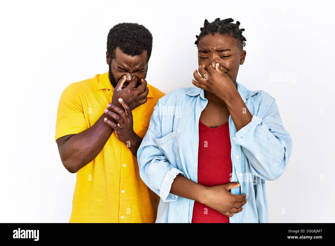 Young african american couple wearing casual clothes smelling something ...