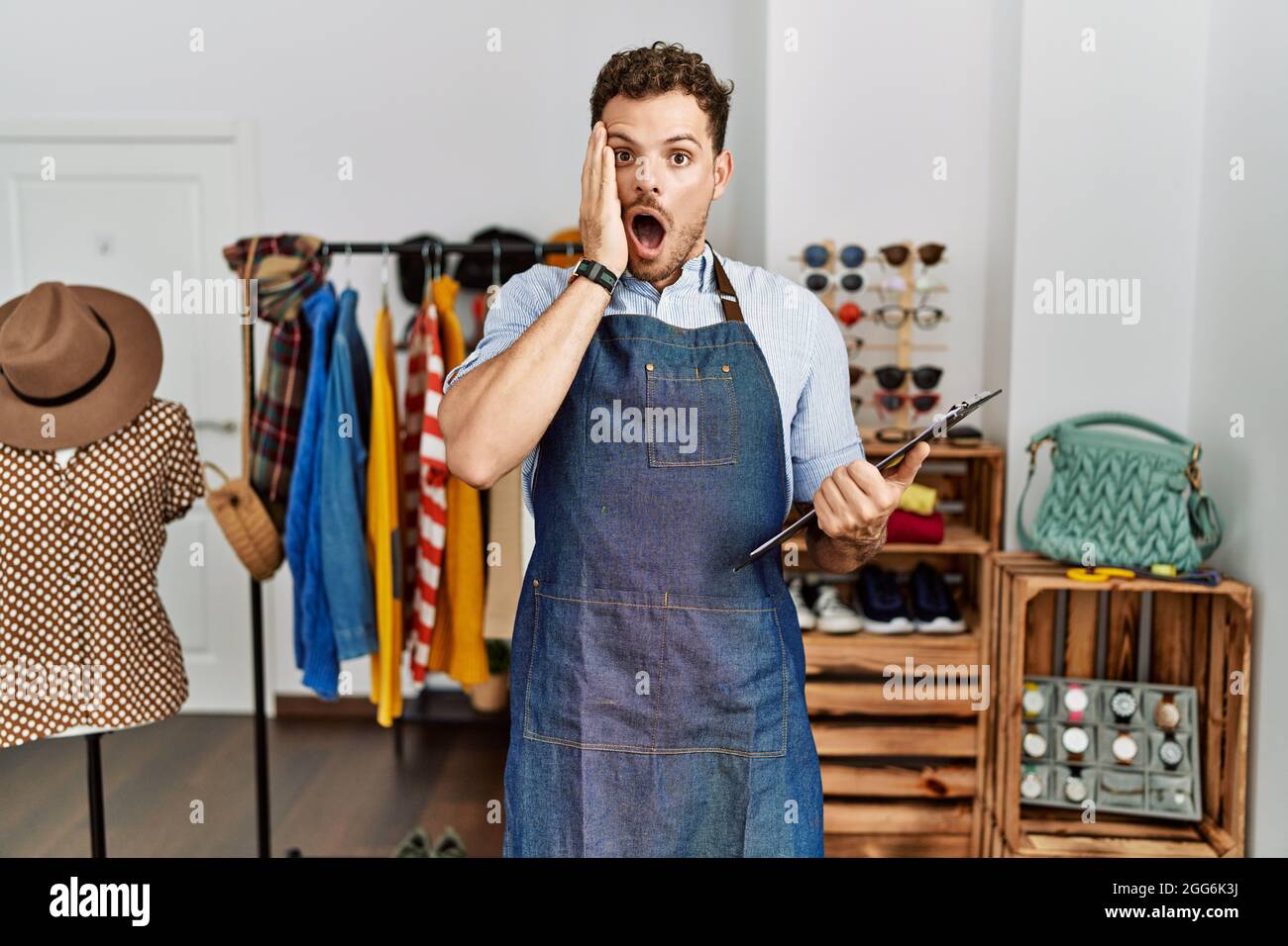 Handsome young man working as manager at retail boutique afraid and ...