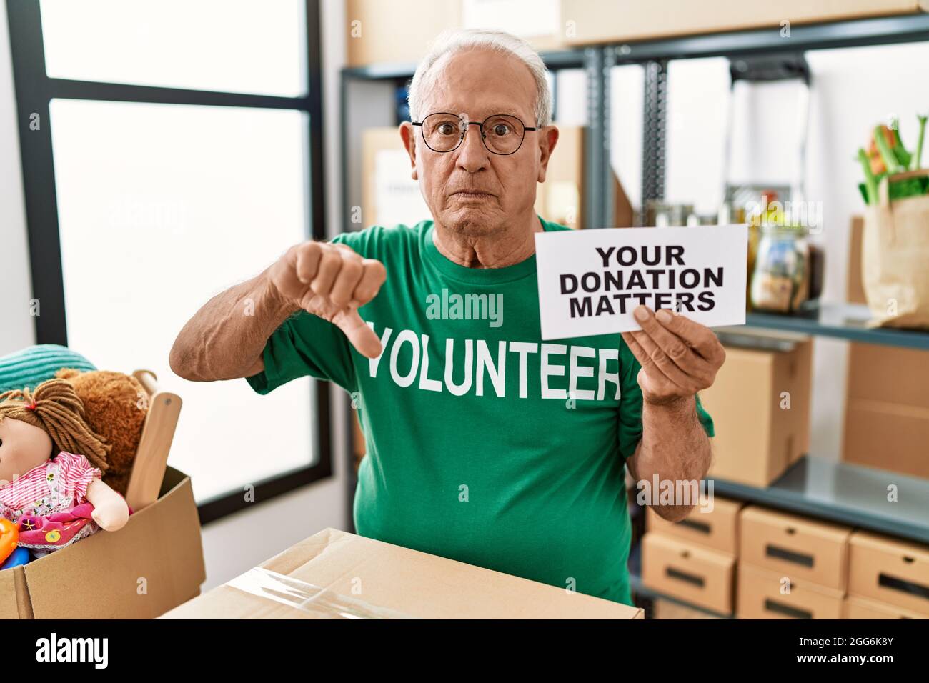 Senior volunteer man holding your donation matters with angry face ...