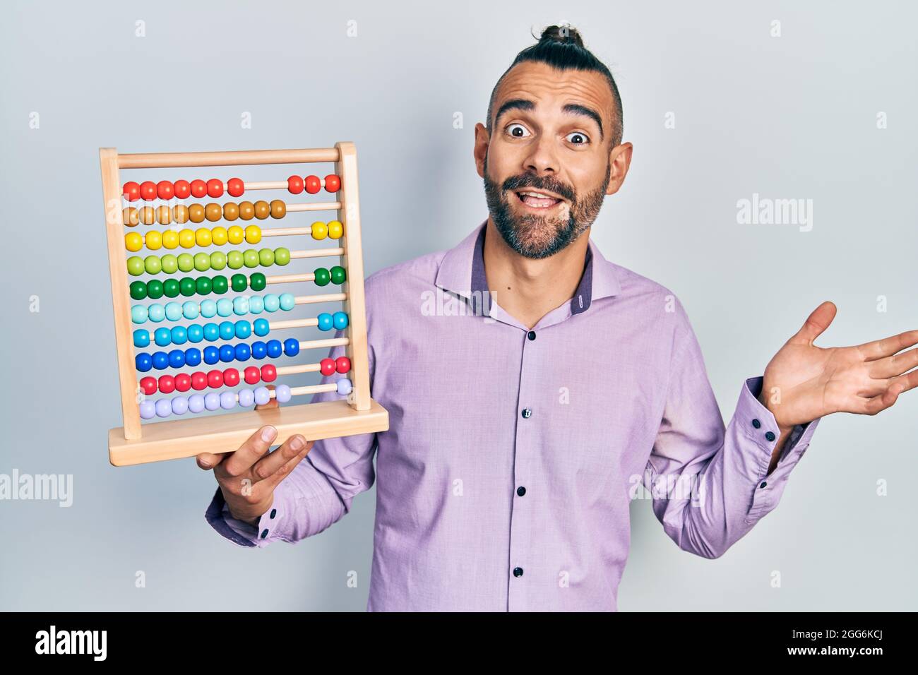 Young hispanic man holding traditional abacus celebrating achievement ...