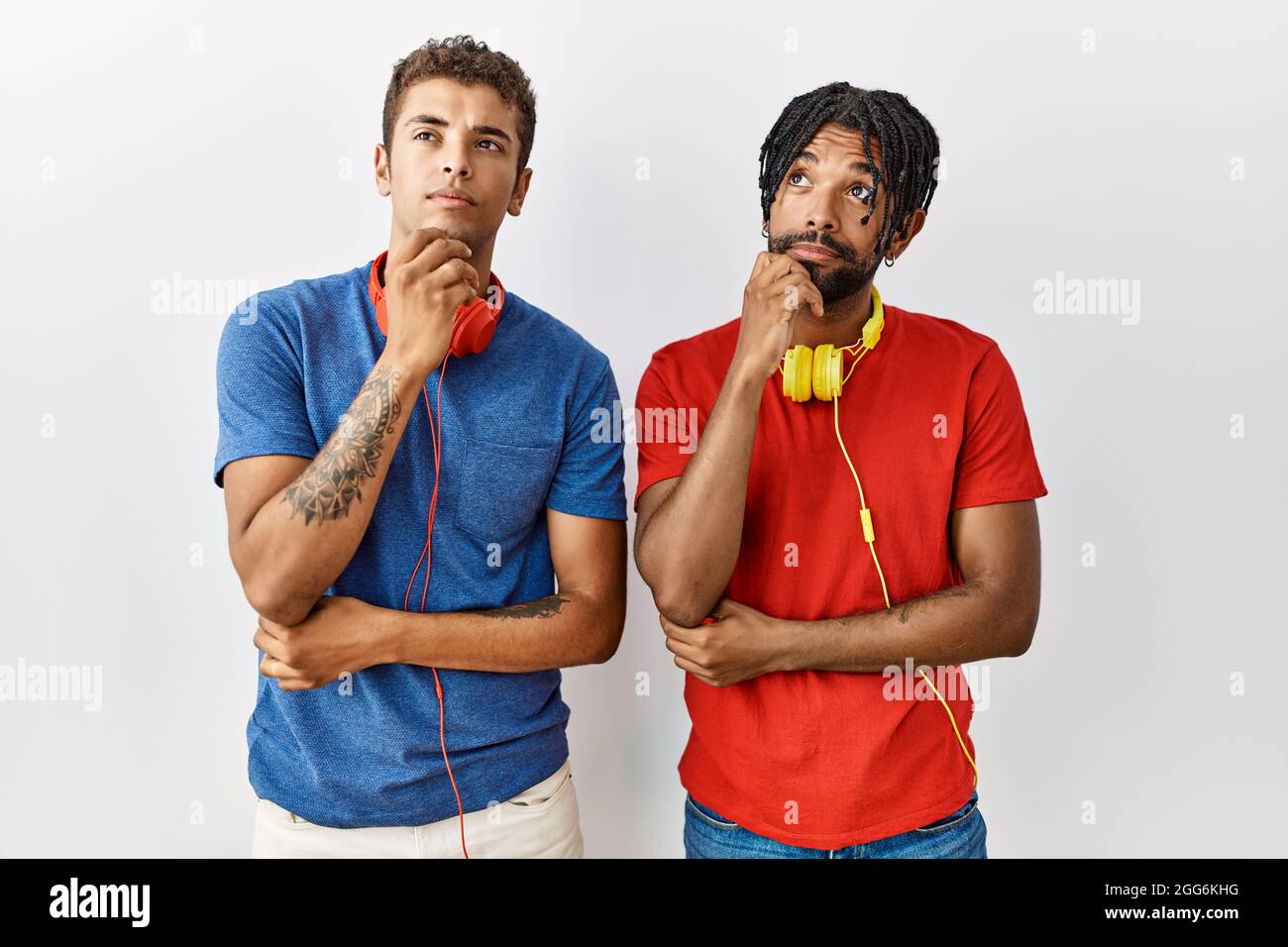 Young hispanic brothers standing over isolated background wearing ...