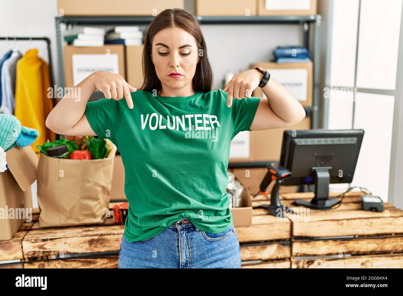 Young brunette woman wearing volunteer t shirt at donations stand ...