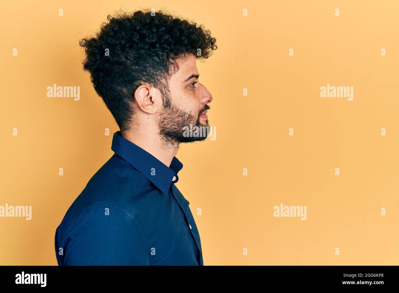 Young arab man with beard wearing casual shirt looking to side, relax ...