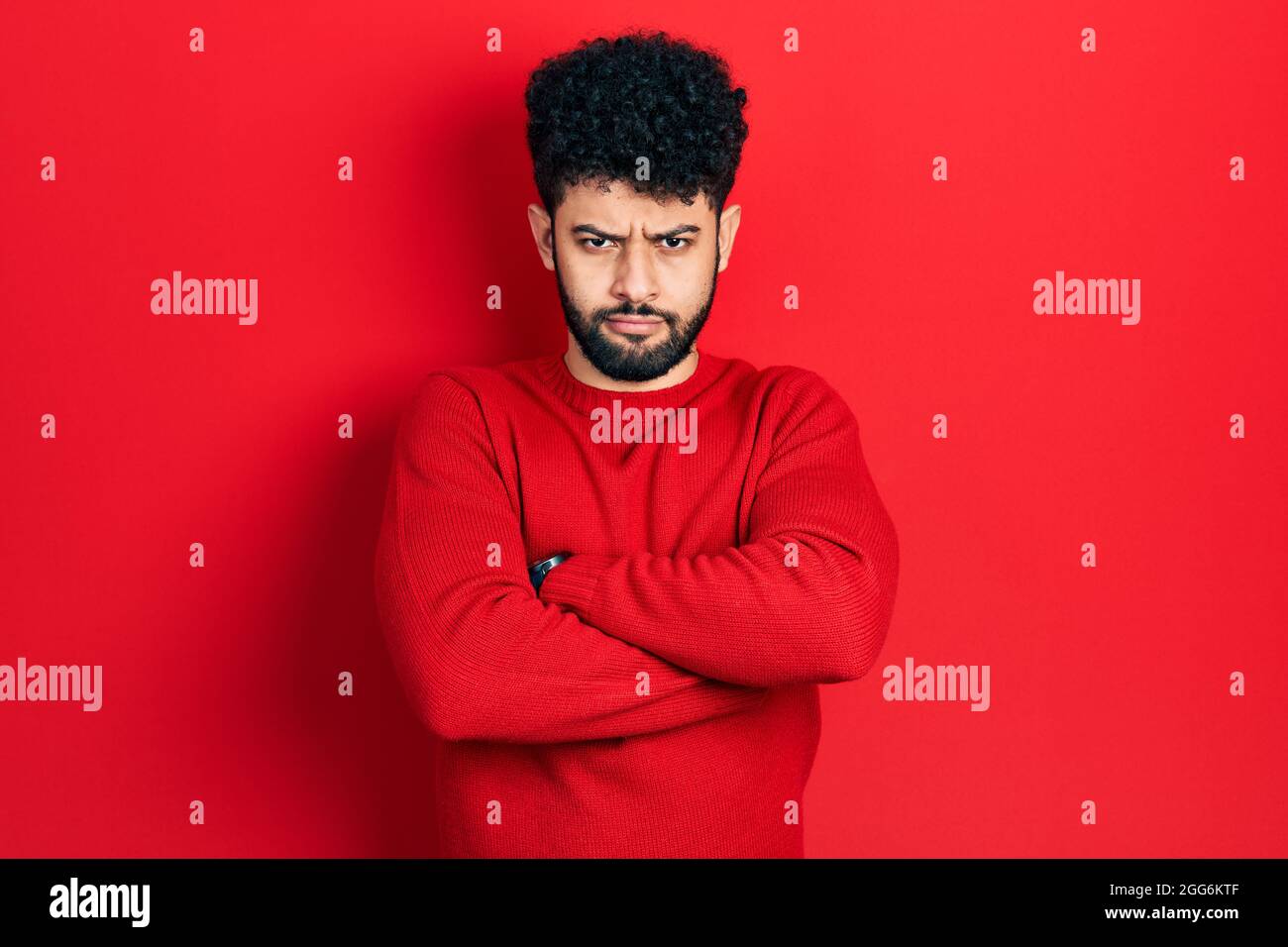 Young arab man with beard wearing casual red sweater skeptic and ...
