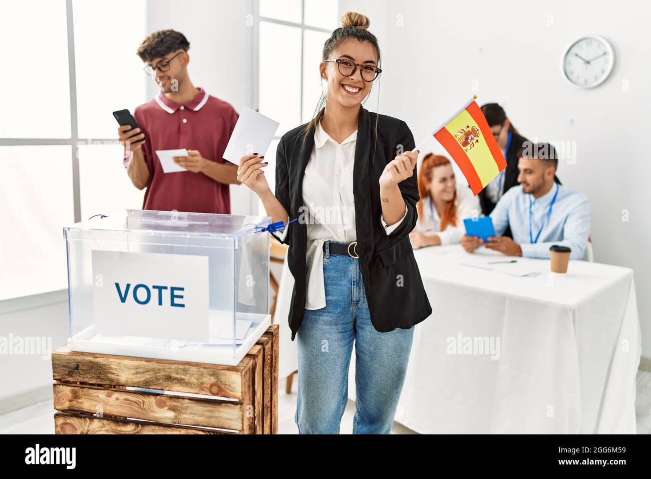 Young spanish voter woman smiling happy holding spain flag at vote ...