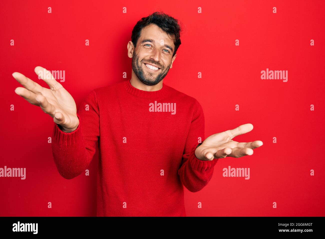 Handsome man with beard wearing casual red sweater smiling cheerful ...