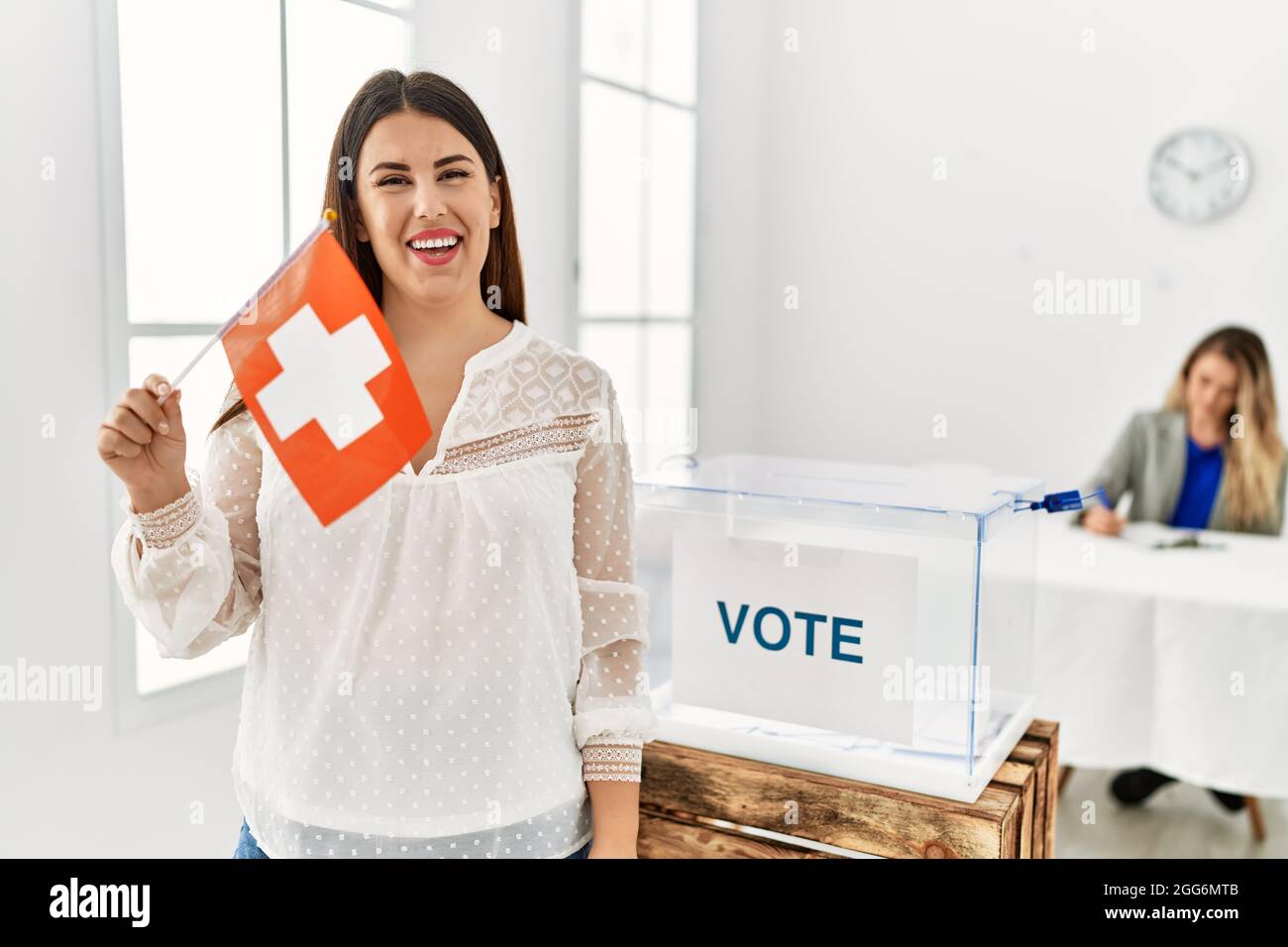 Young swiss voter woman smiling happy holding switzerland flag at ...