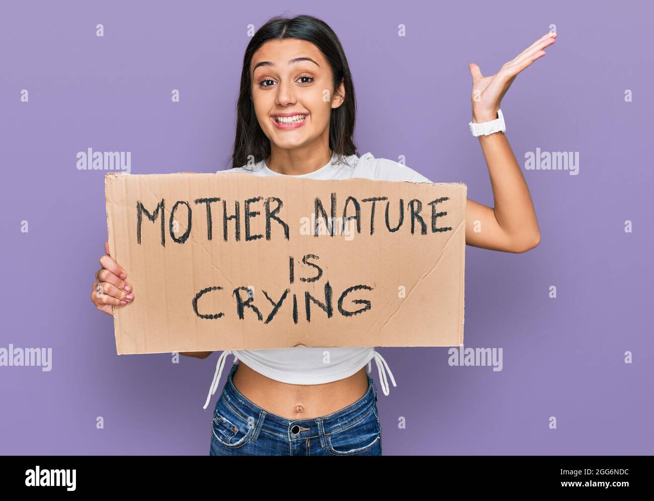 Young hispanic girl holding mother nature is crying protest cardboard ...