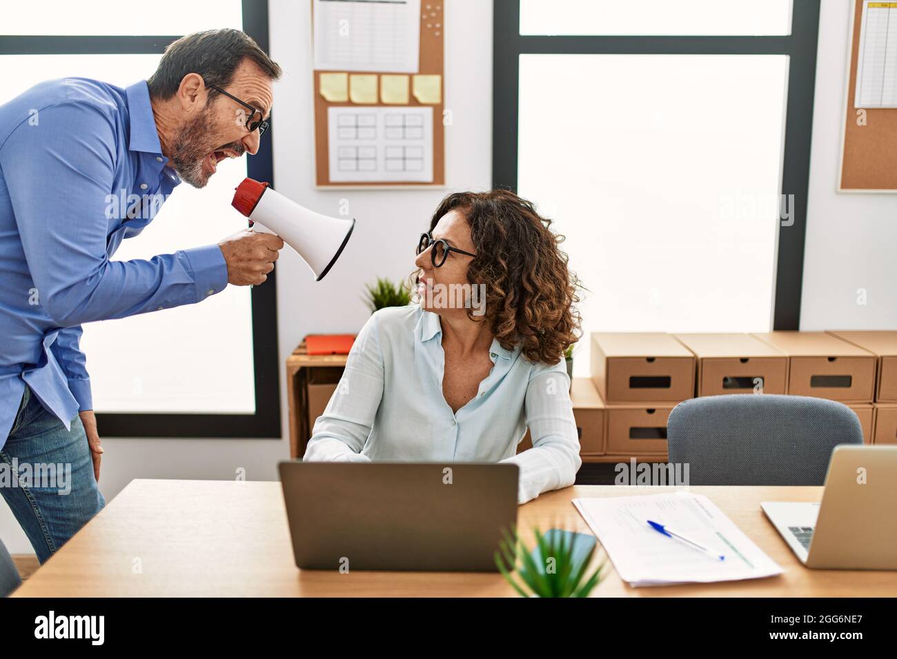 Middle age businessman angry with employee. Screaming using megaphone ...