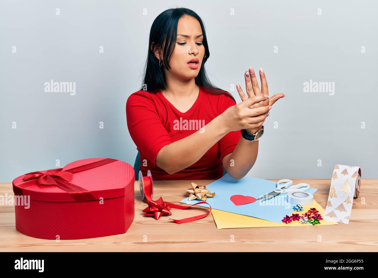 Beautiful hispanic woman with nose piercing doing handcraft creative ...