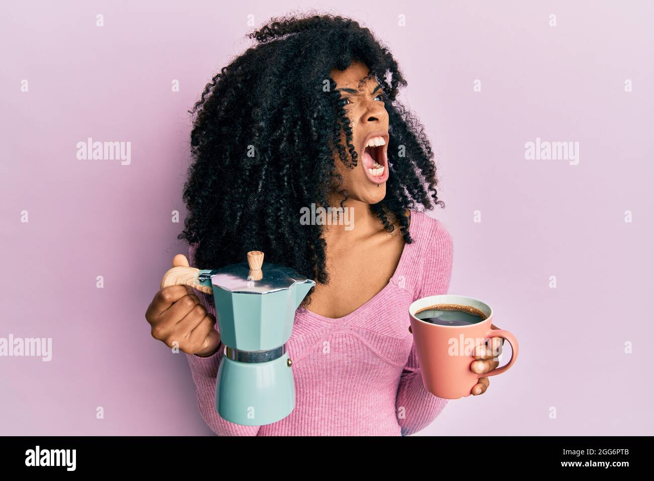 African american woman with afro hair drinking italian coffee angry and ...