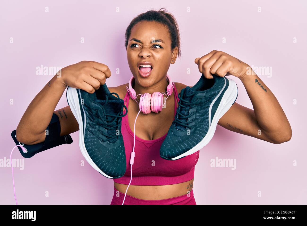 Young african american girl wearing gym clothes, using headphones and ...