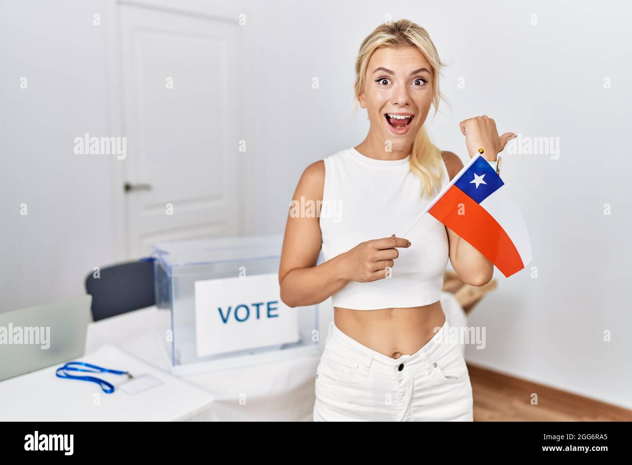Young caucasian woman at political campaign election holding chile flag ...