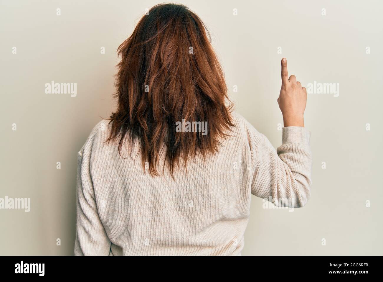 Young caucasian woman wearing casual clothes posing backwards pointing ...