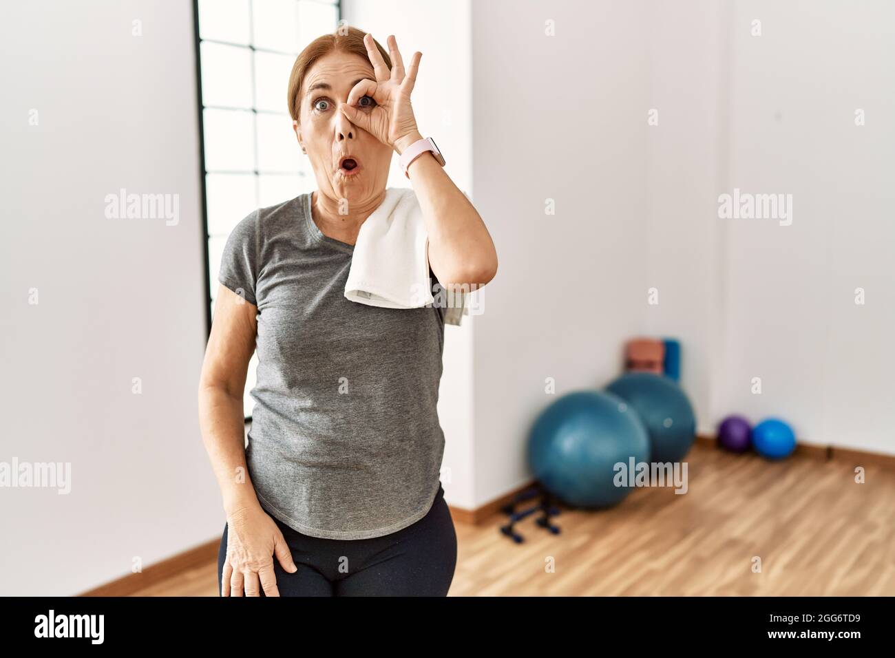 Middle age woman wearing sporty look training at the gym room doing ok ...