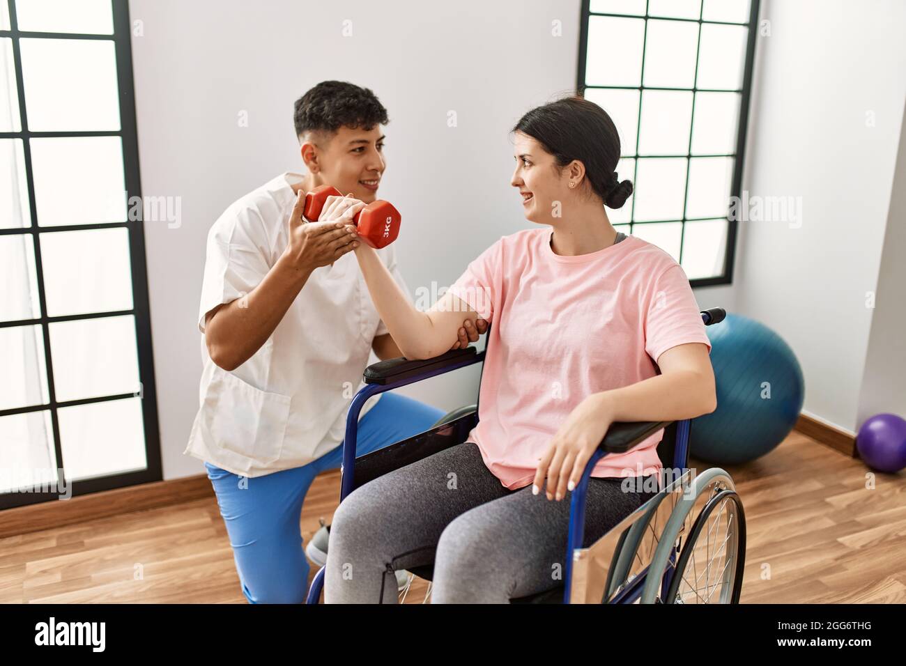 Young disabled woman sitting on wheelchair making mobility exercise ...