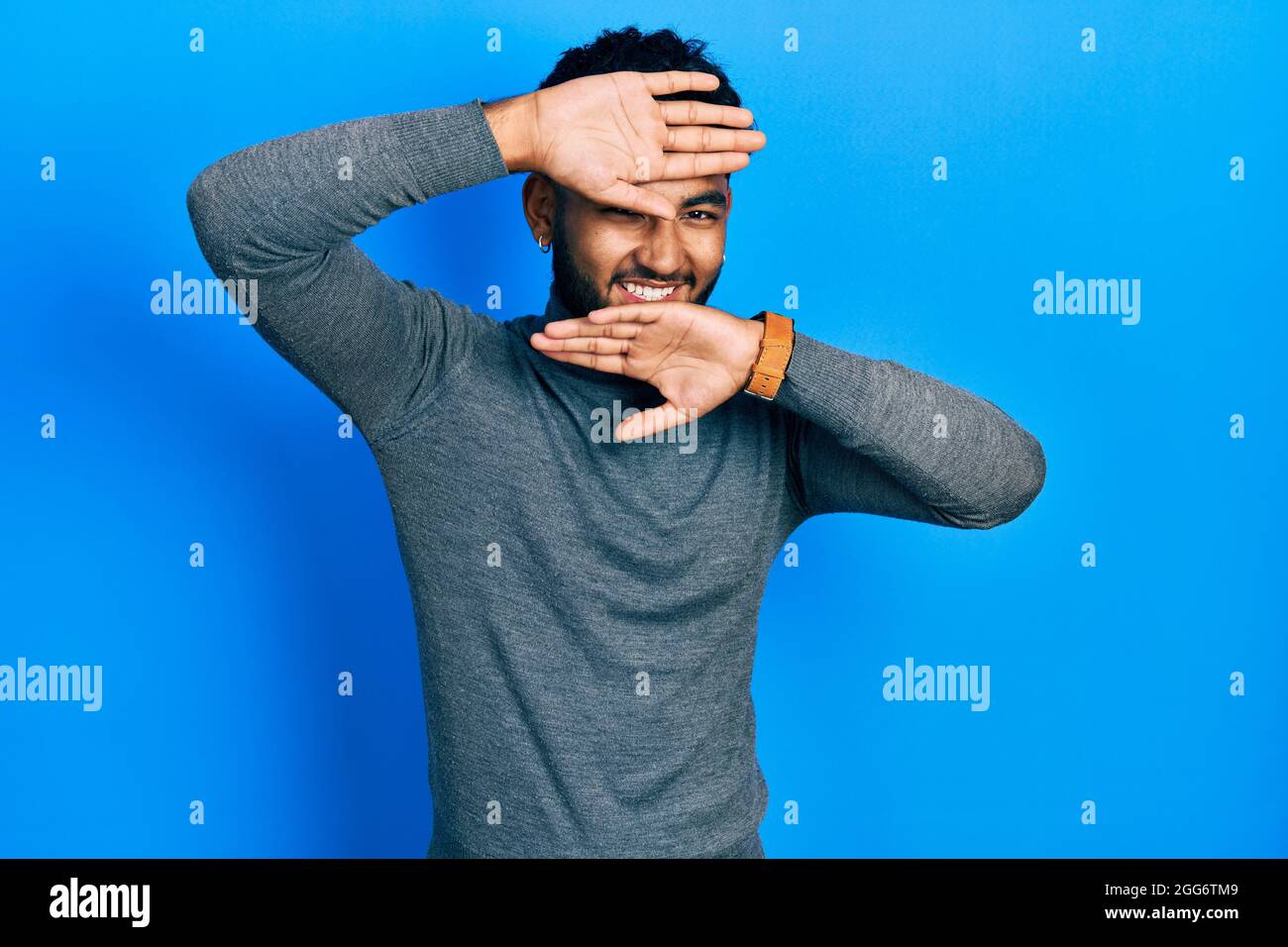 Arab man with beard wearing turtleneck sweater smiling cheerful playing ...