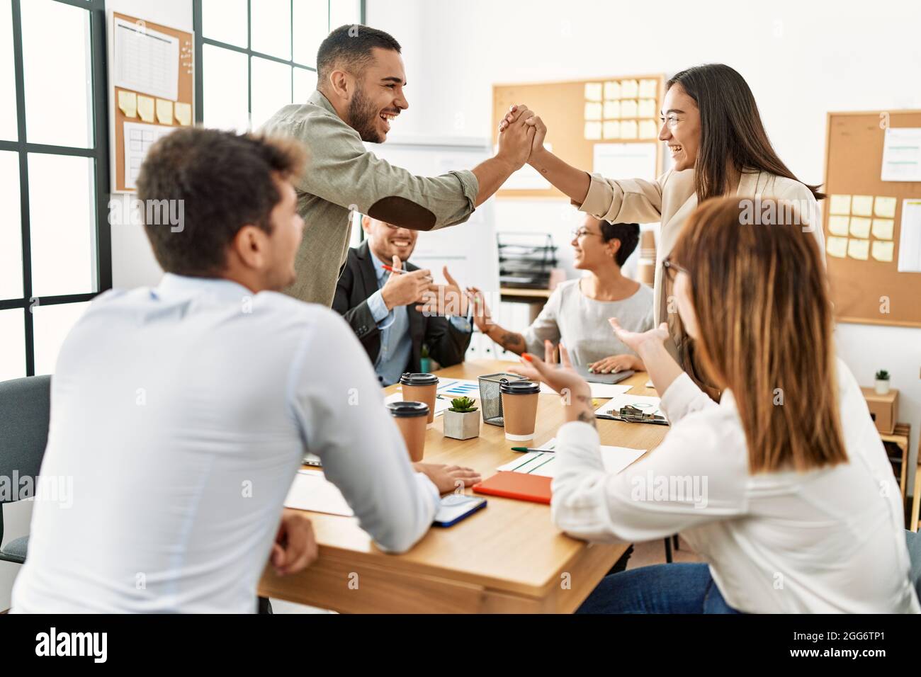 Two workers smiling happy high five during meeting at the office Stock ...
