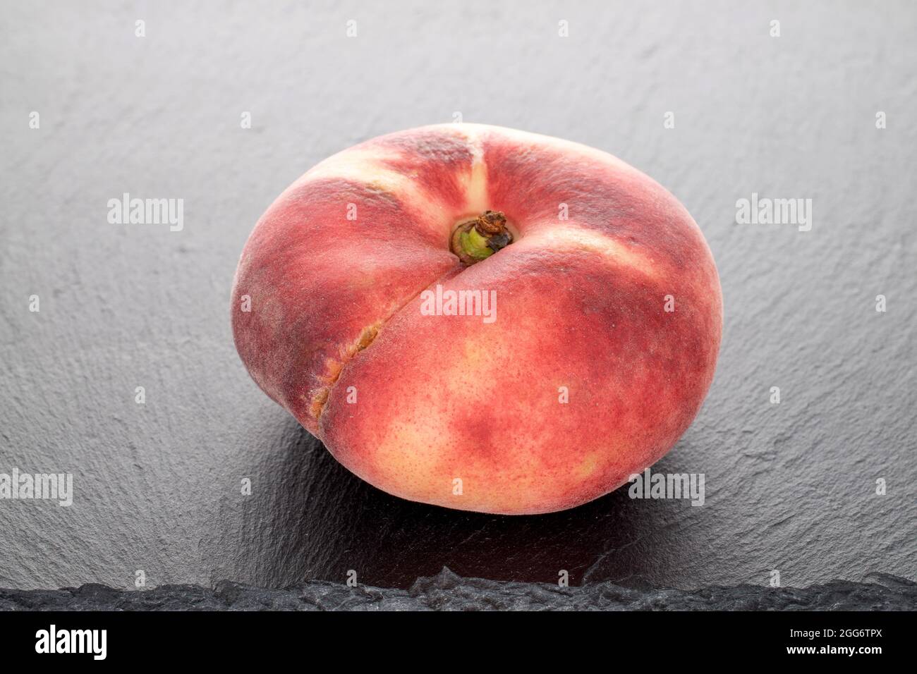 One organic ripe fig peach on a metal tray, close-up Stock Photo - Alamy