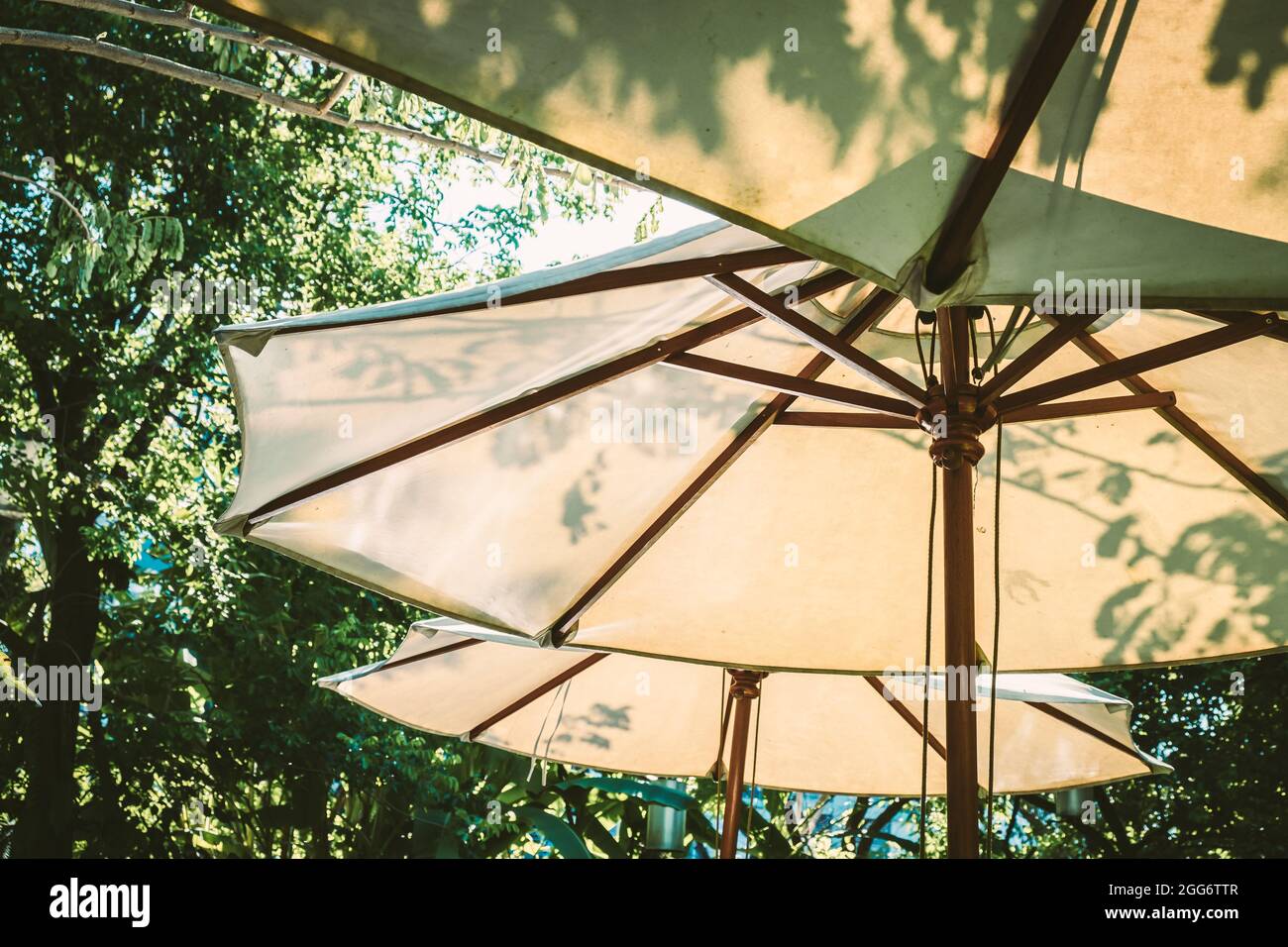 Sunlight through white parasol umbellar. Garden furniture function ...