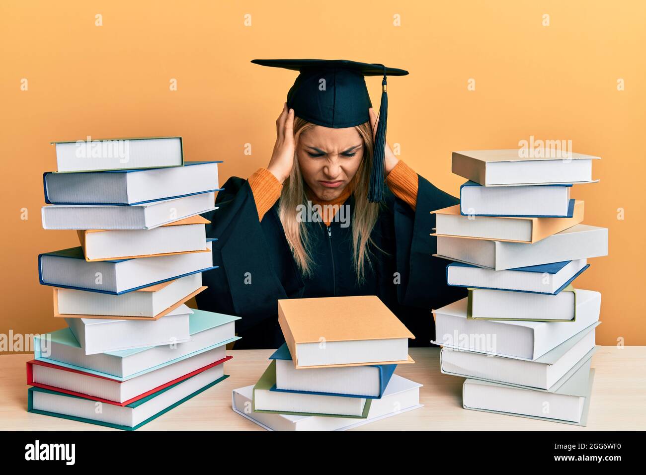 Young caucasian woman wearing graduation ceremony robe sitting on the ...