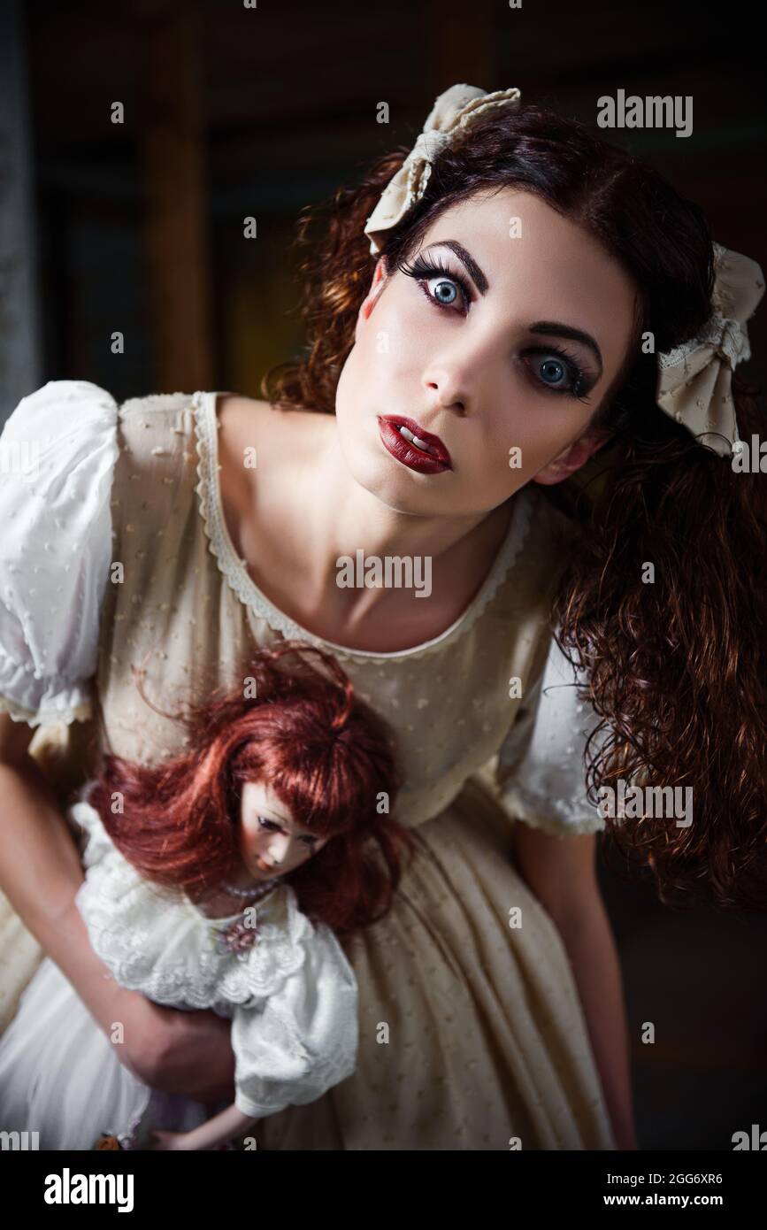 Portrait of a strange girl with doll Stock Photo - Alamy