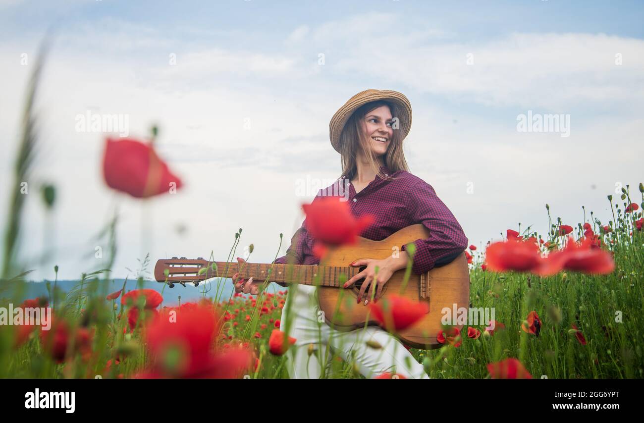 lady wear checkered shirt and hat in flower field. country music singer ...