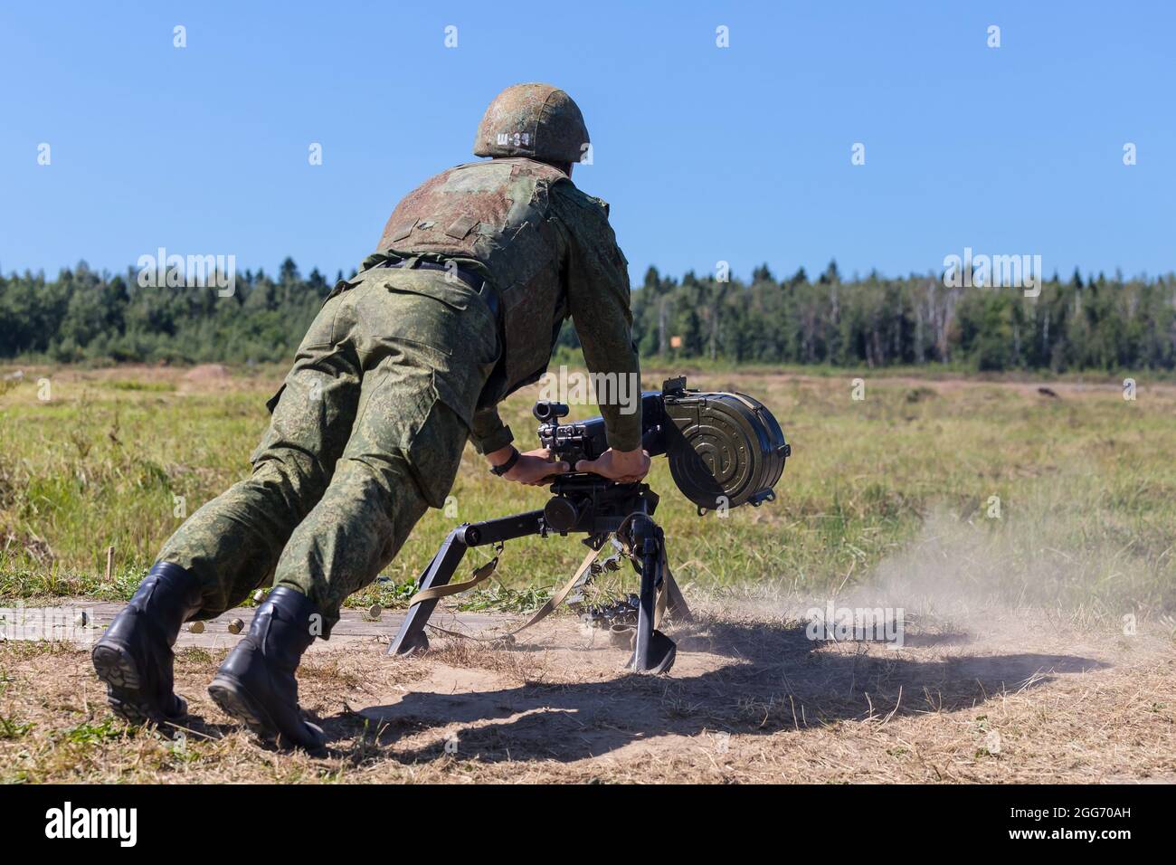 A soldier presses an AGS-17 grenade launcher to the ground while firing ...
