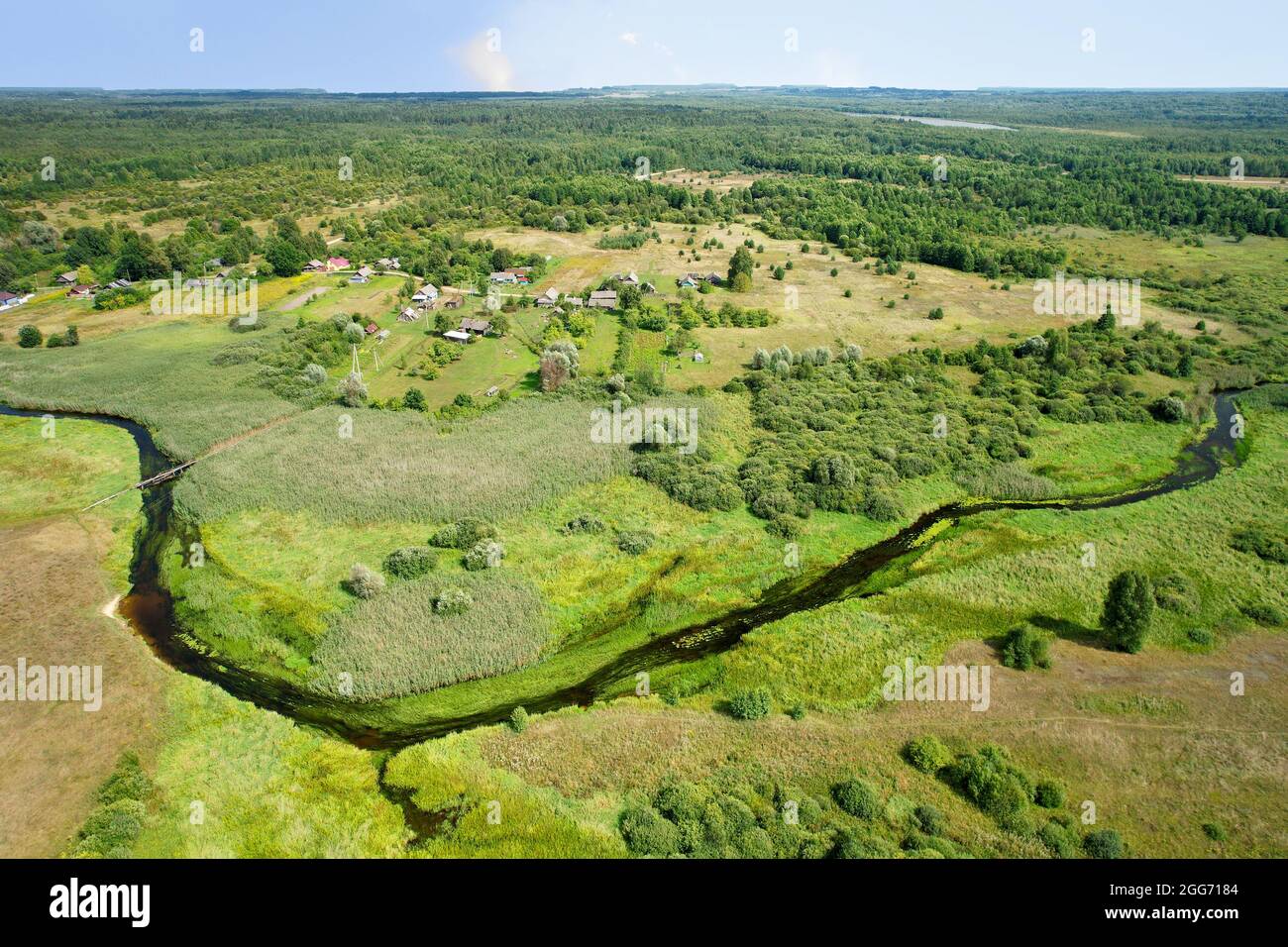 River in the wild. Aerial view of small river in middle of green field ...