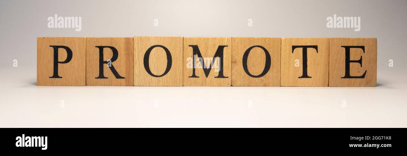 The word PROMOTE was created from wooden cubes Stock Photo - Alamy