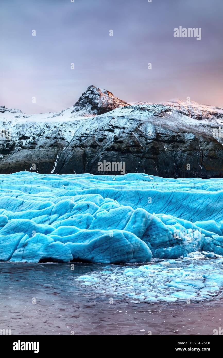 Snow covered mountain and blue glacial ice of the Svinafellsjokul ...
