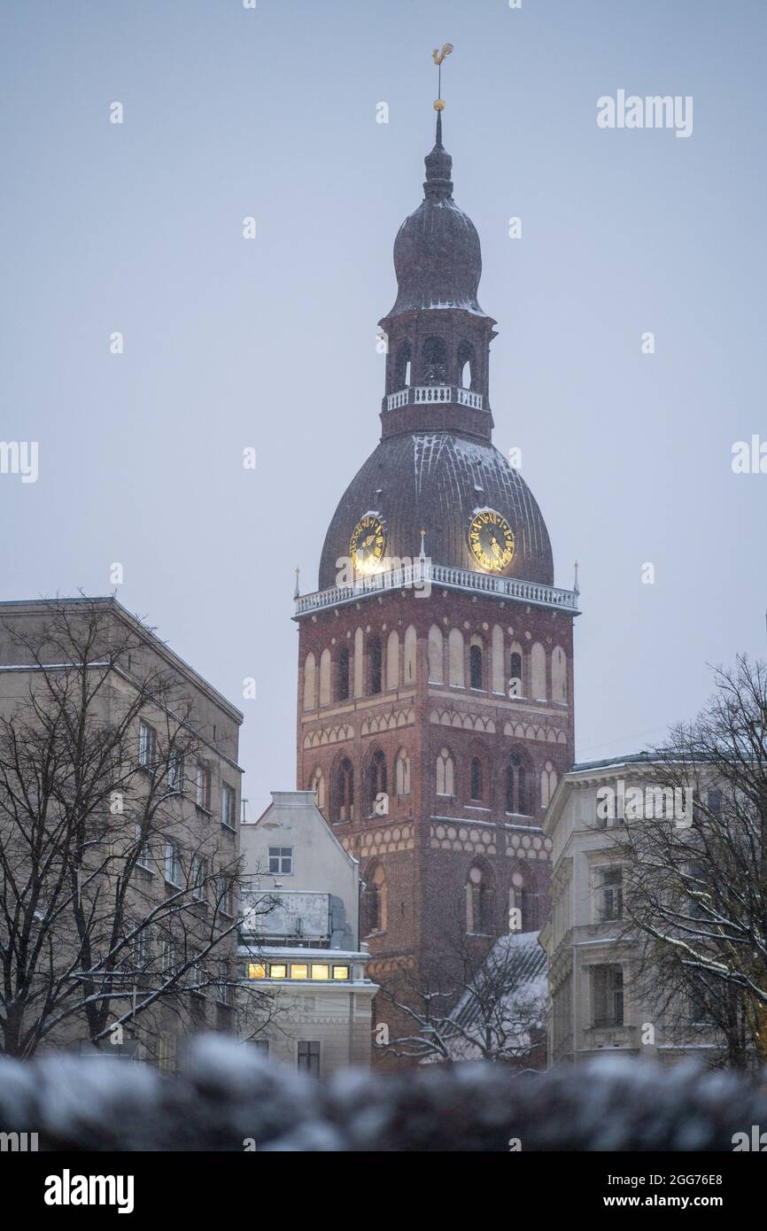 During the snowfall, the Riga Cathedral tower rose over the buildings ...