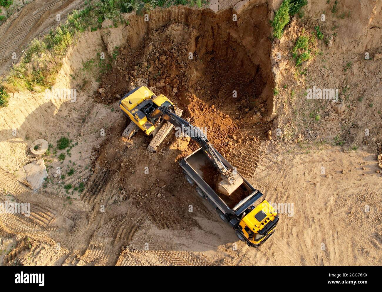 Excavator load the sand into dump truck. Aerial view of an backhoe on ...