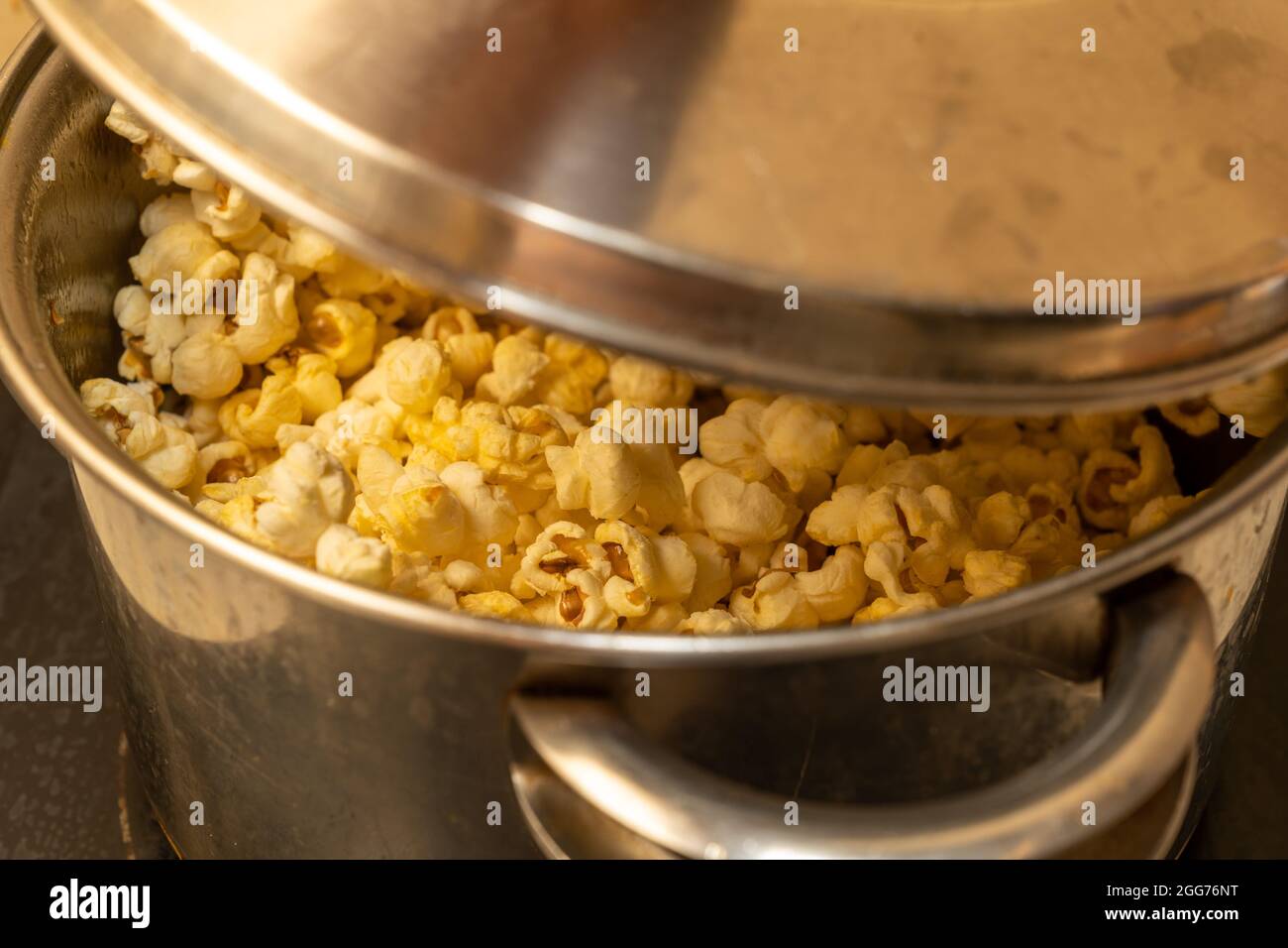 Corn grains and a spices mass are poured into the kitchen pot to make ...