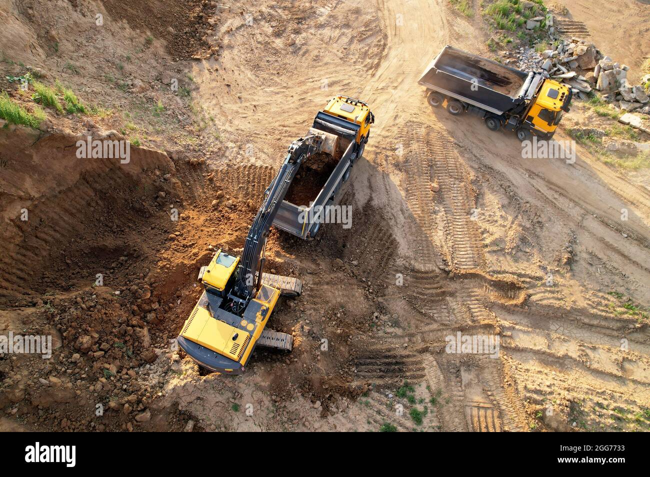 Excavator load the sand into dump truck. Aerial view of an backhoe on ...